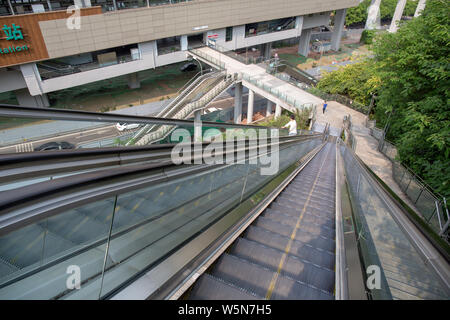 Local residents take the newly-built escalators to reach the top of a ...