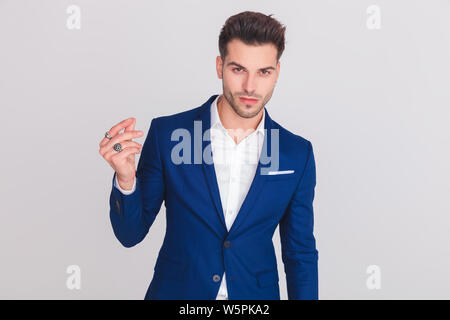 Man snapping his fingers on light grey background, closeup. Bad habit ...