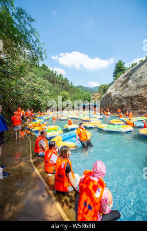A crowd of tourists sitting on inflatable rafts jam Gulong Valley as ...