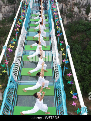 Chinese enthusiasts perform yoga on the edge of a cliff on Laojun ...
