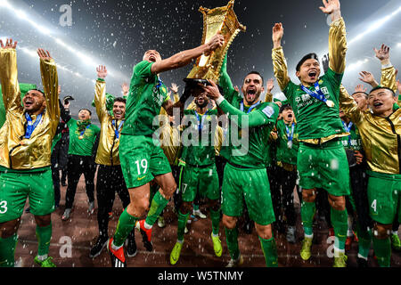 Players of Beijing Sinobo Guoan hold the trophy to celebrate after ...