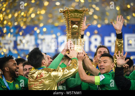 Players of Beijing Sinobo Guoan hold the trophy to celebrate after ...