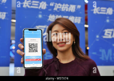 A passenger shows the QR code to be scanned for check-in on his ...