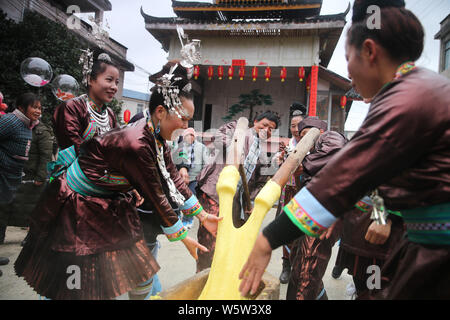 People of Dong ethnic group dressed in traditional costumes carry a ...