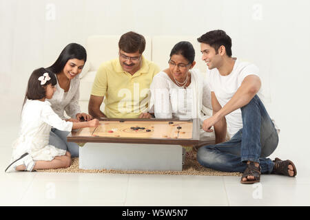 Family playing carom and smiling Stock Photo - Alamy