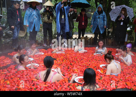 Tourists eat chili and take a hot pepper spring during a contest at a ...
