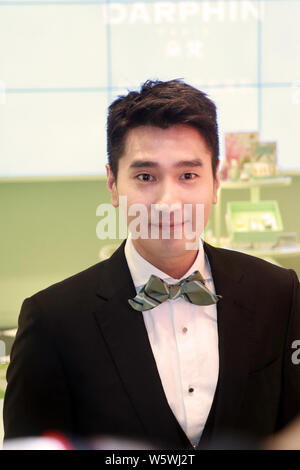 Taiwanese-Canadian actor Mark Chao, right, poses with a wax figure of ...