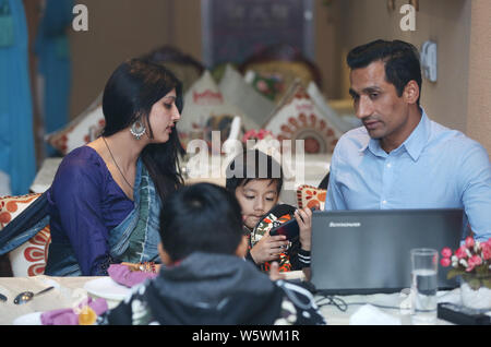 Indian man Dev Raturi, who owns eight restaurants, and his families eat ...