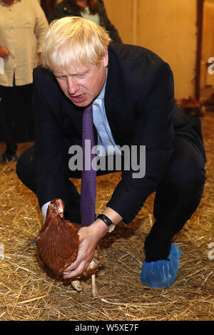 Prime Minister Boris Johnson inspects the chickens during his visit ...