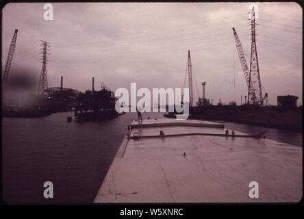 SEAMAN ON LEAD BARGE INDICATES CLEARANCE AS TUG PUSHES BARGES TOWARD ...