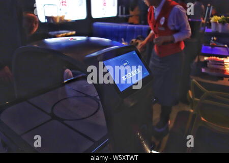 A robot waiter delivers dishes ordered by customers to the table at the ...