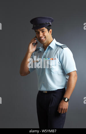 Airforce pilot talking on a mobile phone smiling Stock Photo - Alamy
