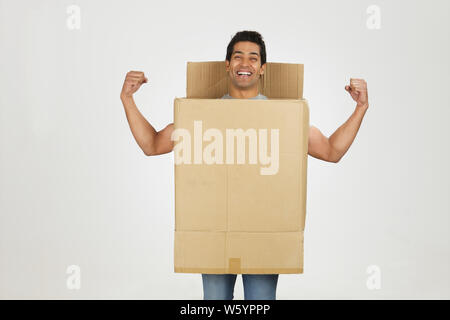 Man wearing cardboard box flexing muscles Stock Photo - Alamy