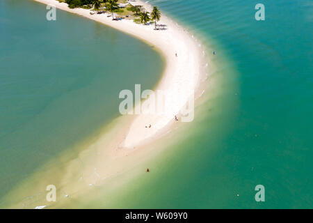 Aerial view of a sand spit leading into the ocean from a green ...
