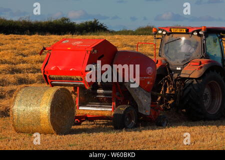 A modern straw compactor collecting the straw and rolling it into huge ...