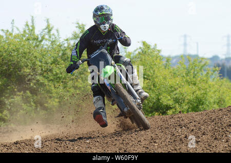 Motorbike rider on scramble bike, jumping high in blue sky. Motocross ...
