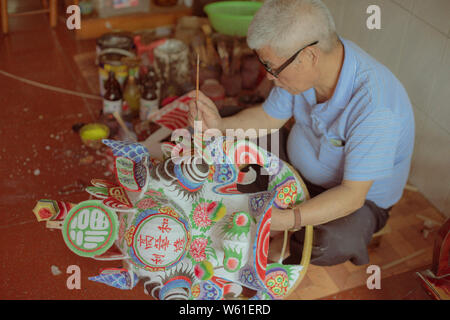 A craftsman makes a head of Qilin, to perform Qilin Dance at a workshop ...