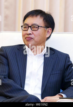 Anning Chen, CEO of Ford China, removes a face mask with the Ford ...