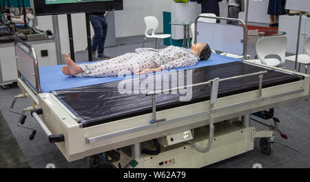 Patient dummy lying on mobile hospital bed while medic adjusting Stock ...