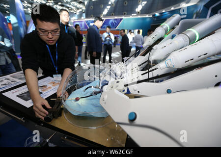 Members of the press look at a porotic laparoscopic surgery robot ...