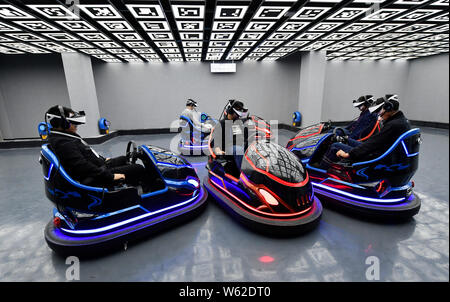 Visitors try out VR devices to ride dodgem cars at the SoReal VR ...