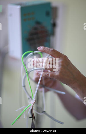 Female doctor or nurse prepares a system for transfusion of infusion ...