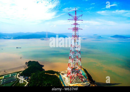 Workers labor at the world's tallest transmission towers that support the 2,656-meter-long power ...