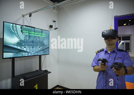A Chinese worker tries out a VR device to check a "Fuxing" high-speed ...
