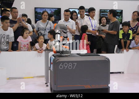 An AI-powered porter robot equipped with a mechanical arm developed by ...
