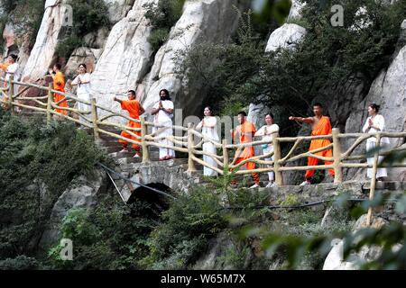 In this aerial view, Yoga lovers practice yoga and Shaolin students ...