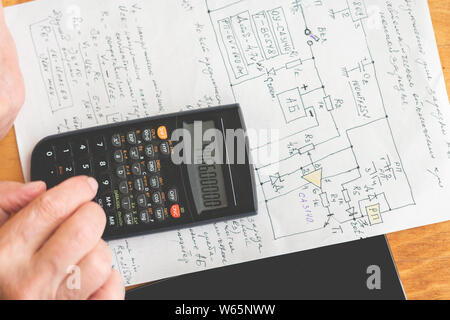 old man doing some math calculations using digital calculator at his ...