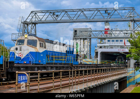 --FILE--Passenger trains runs to disembark from a ferry at the Nangang ...