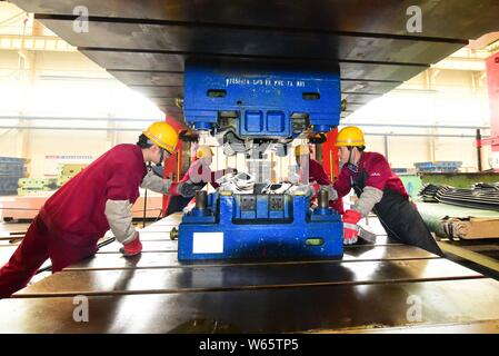 --FILE--A Chinese worker assembles a truck on the assembly line at an ...