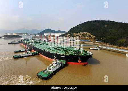 An oil tanker carrying imported crude oil docks at a berth in Qingdao ...