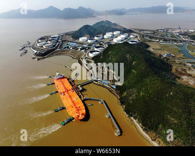 An oil tanker carrying imported crude oil docks at a berth in Qingdao ...