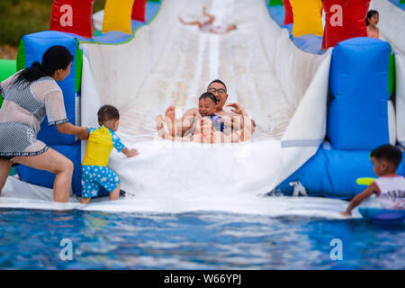 Tourists play on Asia's longest water slide at Jingzhihu Resort in ...