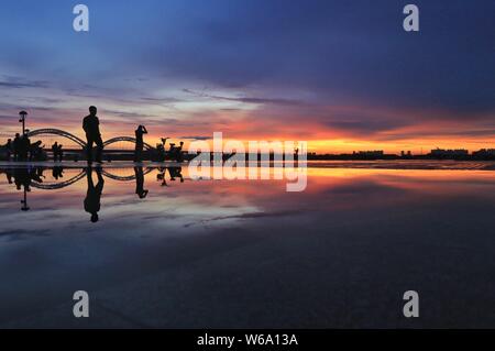 Pedestrians and visitors walk along the Songhuajiang River or Songhua ...