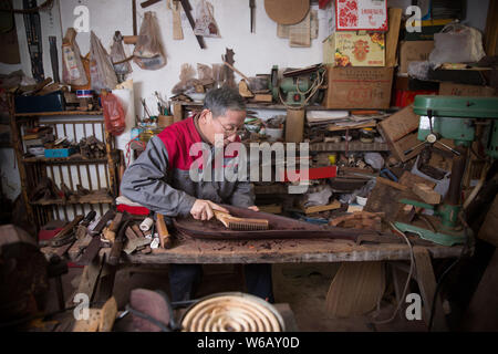 --FILE--Chinese craftsman Li Zhaolin carves Pipa, a four-stringed ...