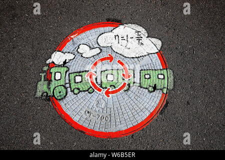 A manhole cover is decorated with special cartoon graffiti ...