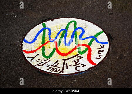 A manhole cover is decorated with special cartoon graffiti ...