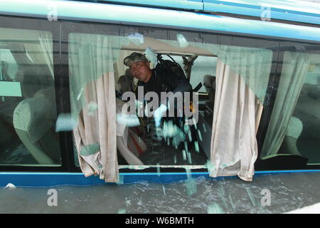 A member of rescue team from Zhengzhou Red Cross conducts an underwater ...