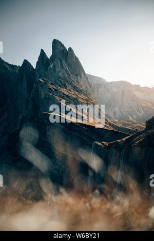 A vertical shot of the rocky Seceda mountain in Italy with the sunlight ...