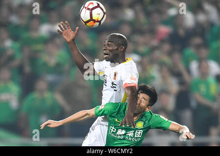 Festus Baise of Guizhou Hengfeng heads the ball against Jiangsu Suning ...