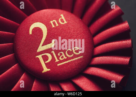 Closeup winner 2nd place red rosette with gold text on black background ...