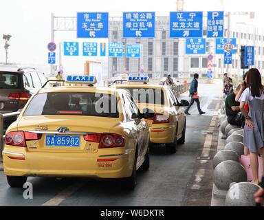 --FILE--Chinese passengers wait for taxis at a taxi station of taxi ...