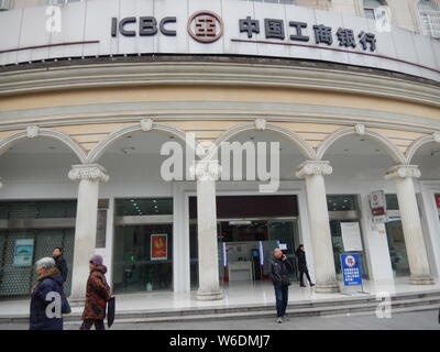 Pedestrians walk past a branch of ICBC (Industrial and Commercial Bank ...