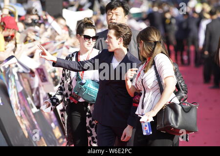 English actor Tom Holland signs autographs for fans as he arrives on ...