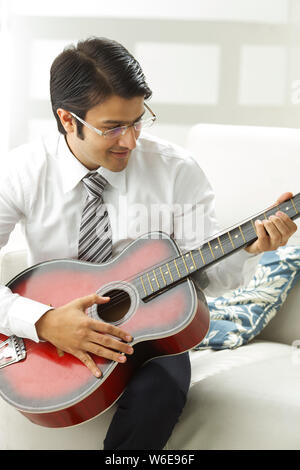 The businessman playing guitar at home Stock Photo - Alamy