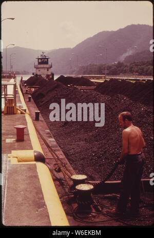 A COALBURG TUG AND EIGHT COAL BARGES GO DOWNSTREAM THROUGH THE LONDON ...
