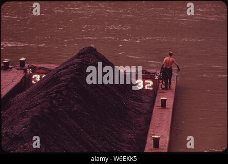 A COALBURG TUG AND EIGHT COAL BARGES GO DOWNSTREAM THROUGH THE LONDON ...